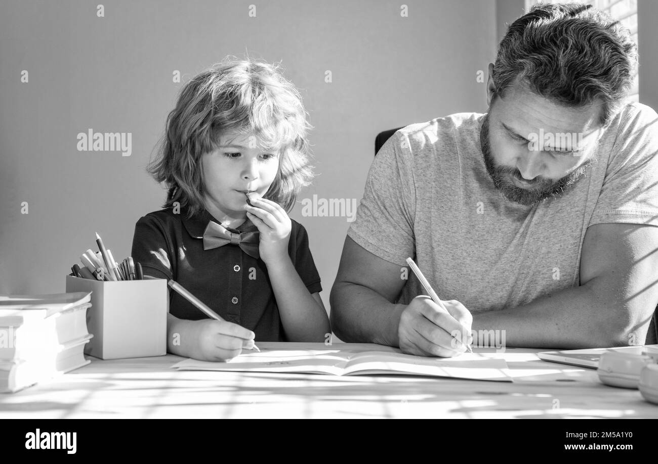 bearded father writing school homework with his boy son in classroom ...