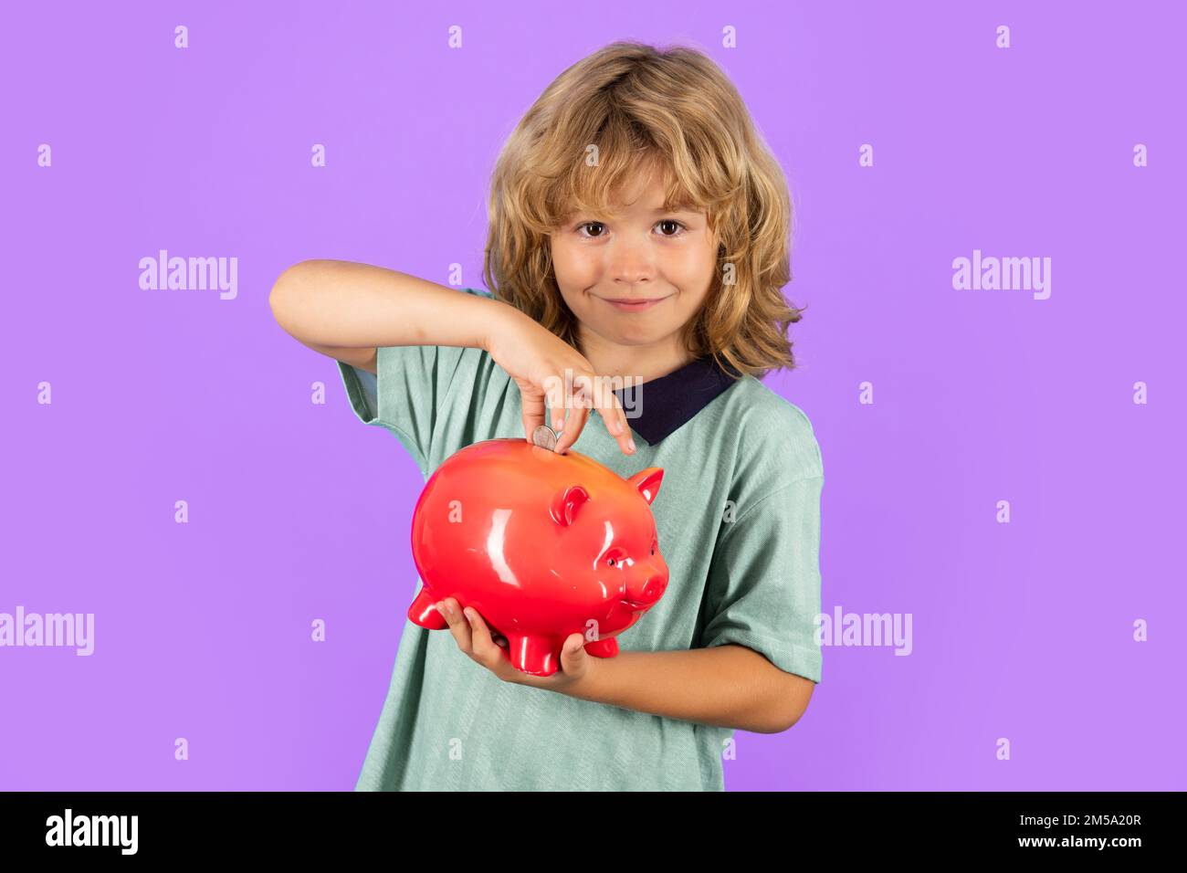 Saving money concept. Portrait of a little boy putting money on a ...