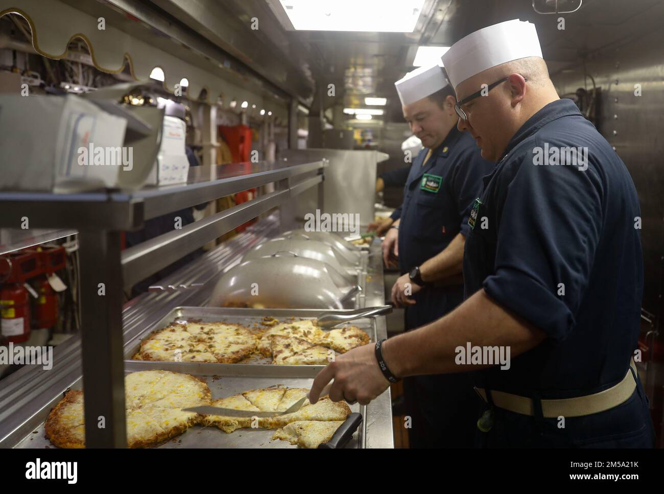 PACIFIC OCEAN (Feb. 14, 2022) Members of the Chiefs Mess serve pizza ...