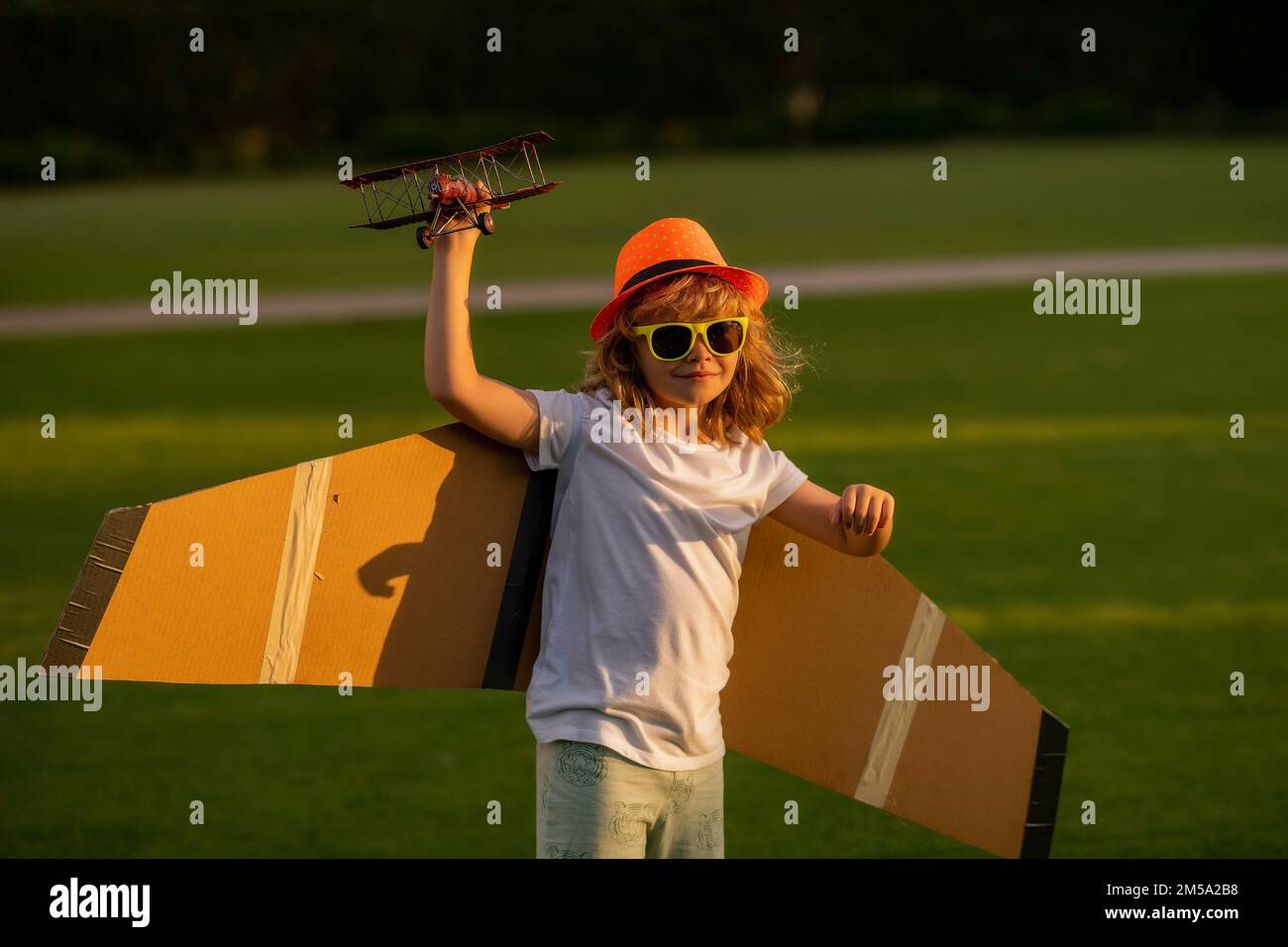 Child playing with plane wings. Summer kids at countryside. Childhood ...