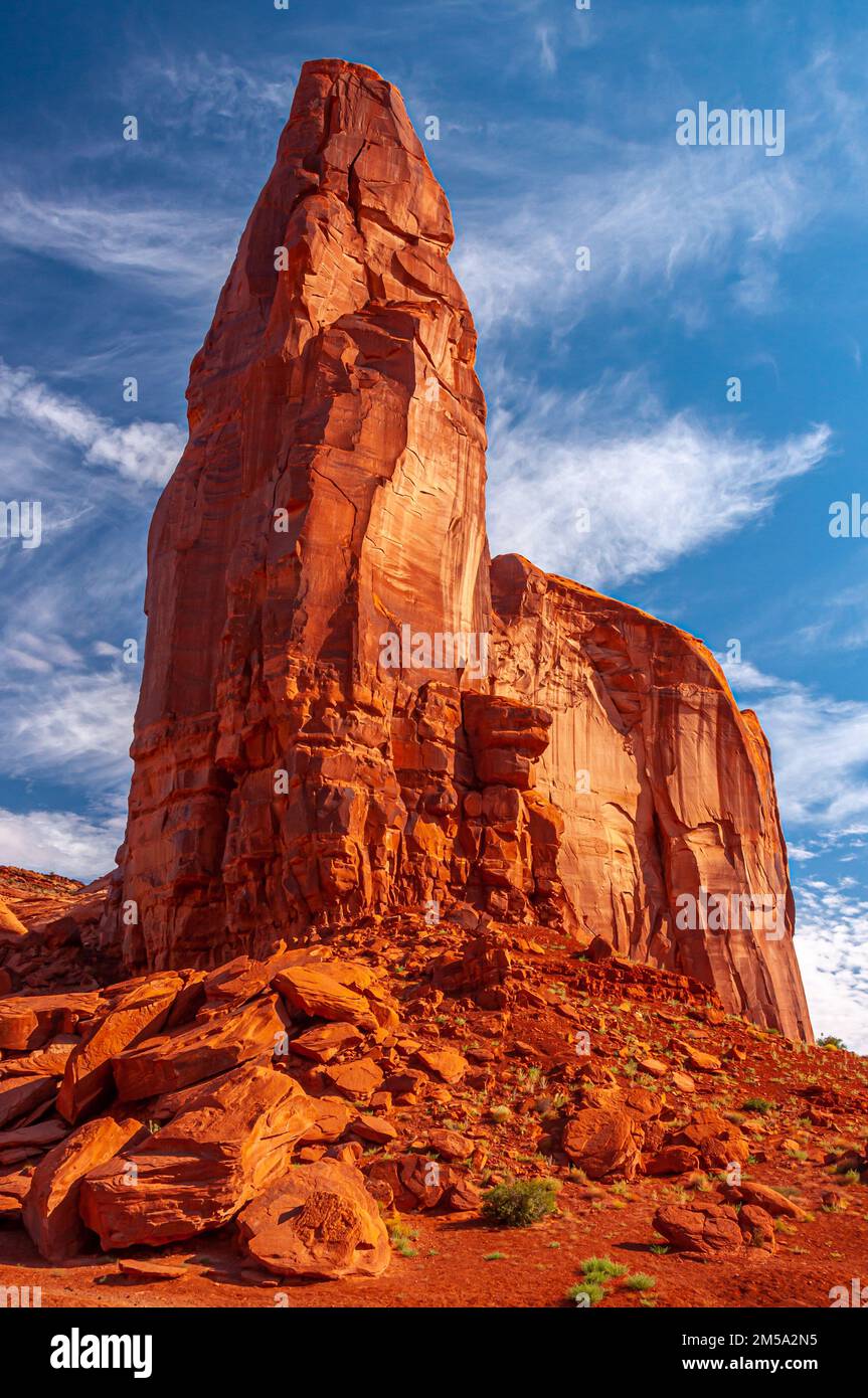 A large monolithic stone stands high overhead against a brilliant blue ...