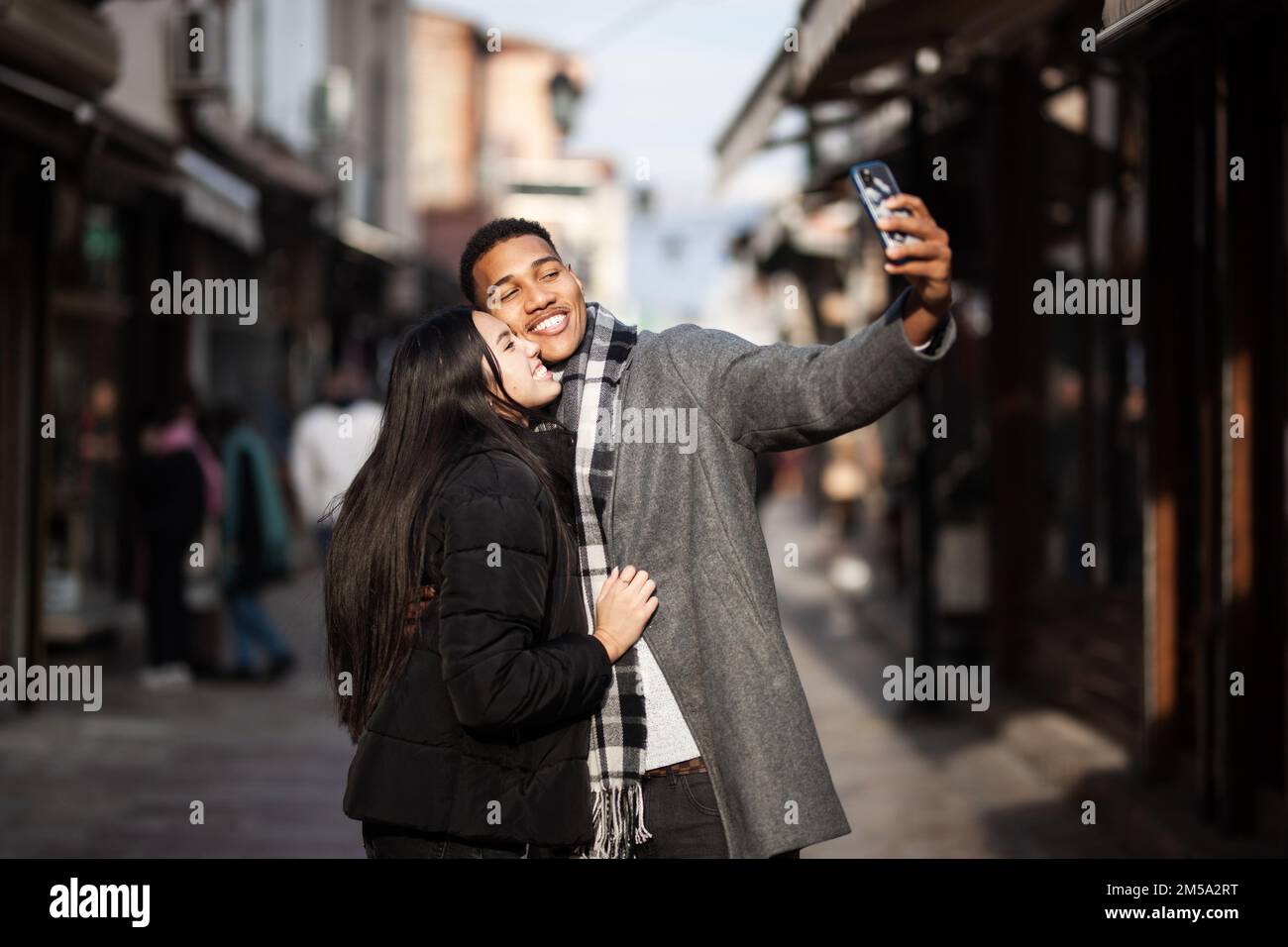 Multiracial couple posing on narrow streets in old part of the sity ...