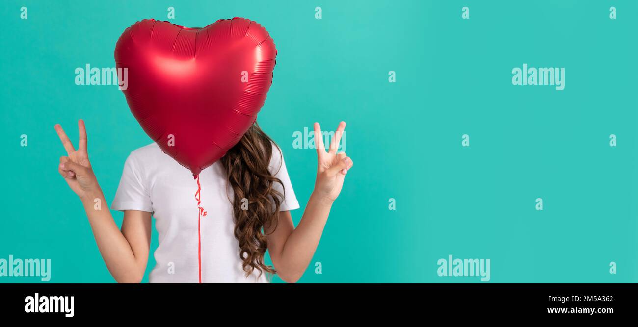 teen girl hiding behind red heart party balloon for valentines day love ...