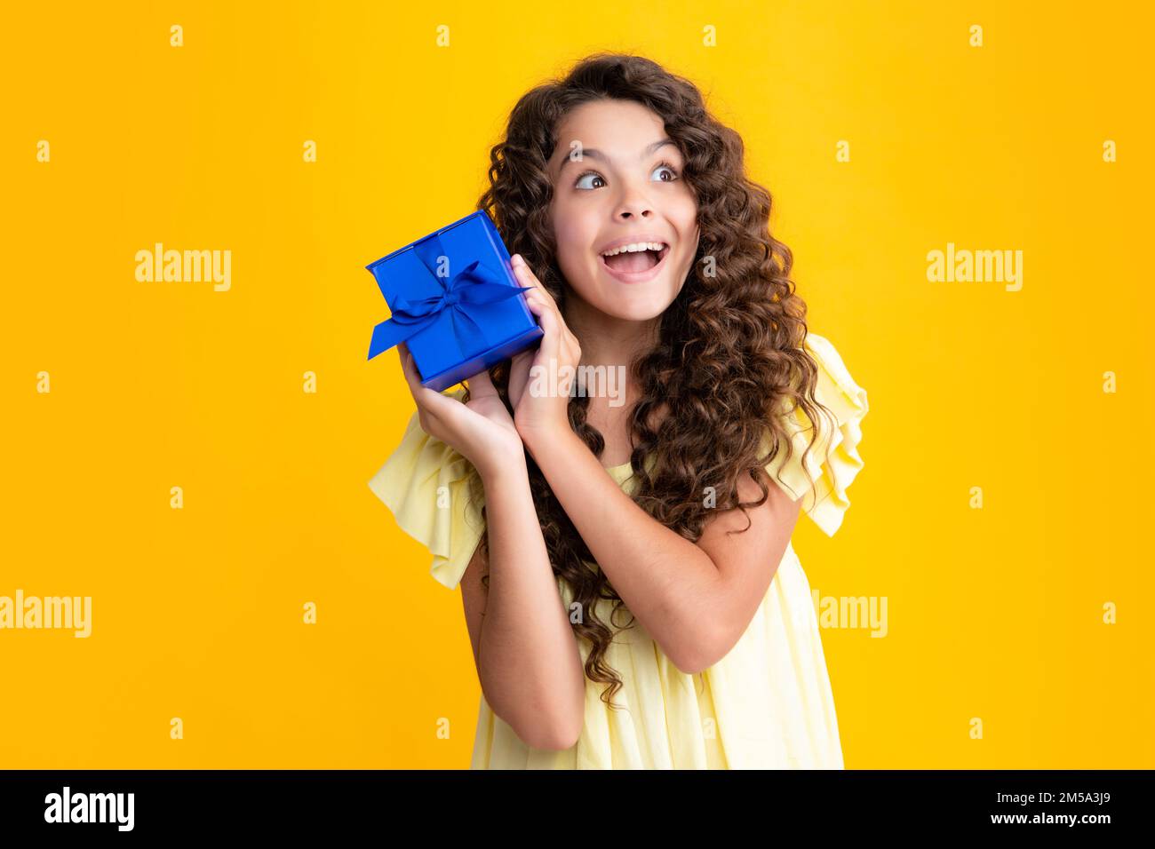 Child with gift present box on isolated studio background. Gifting for ...