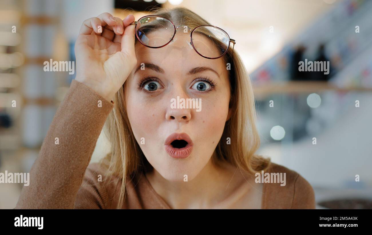 Close up female amazing face portrait emotional confused girl surprised opening mouth takes off ...