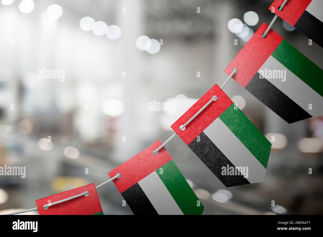 A garland of United Arab Emirates national flags on an abstract blurred ...