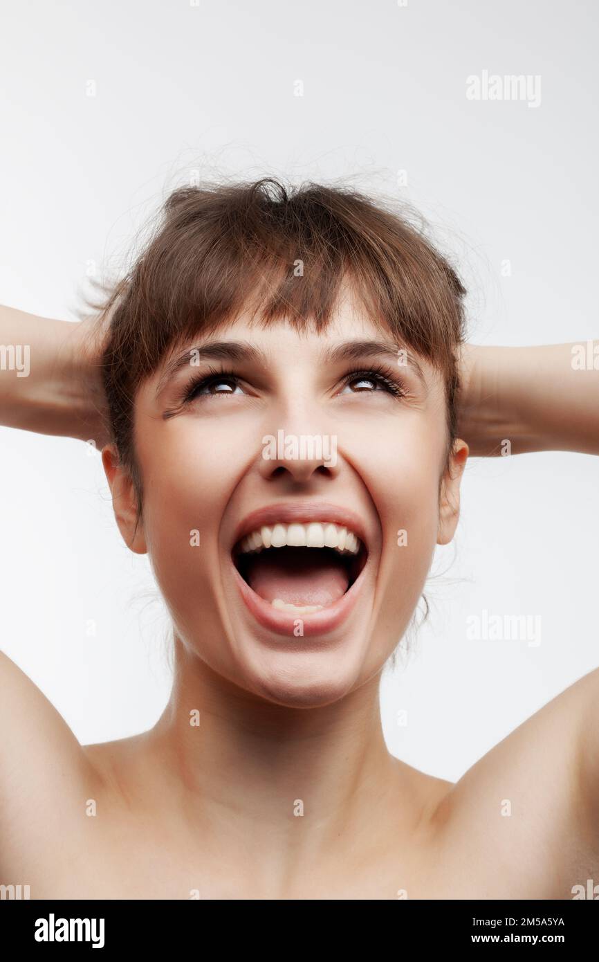 studio portrait of a screaming beautiful brunette girl with short hair ...