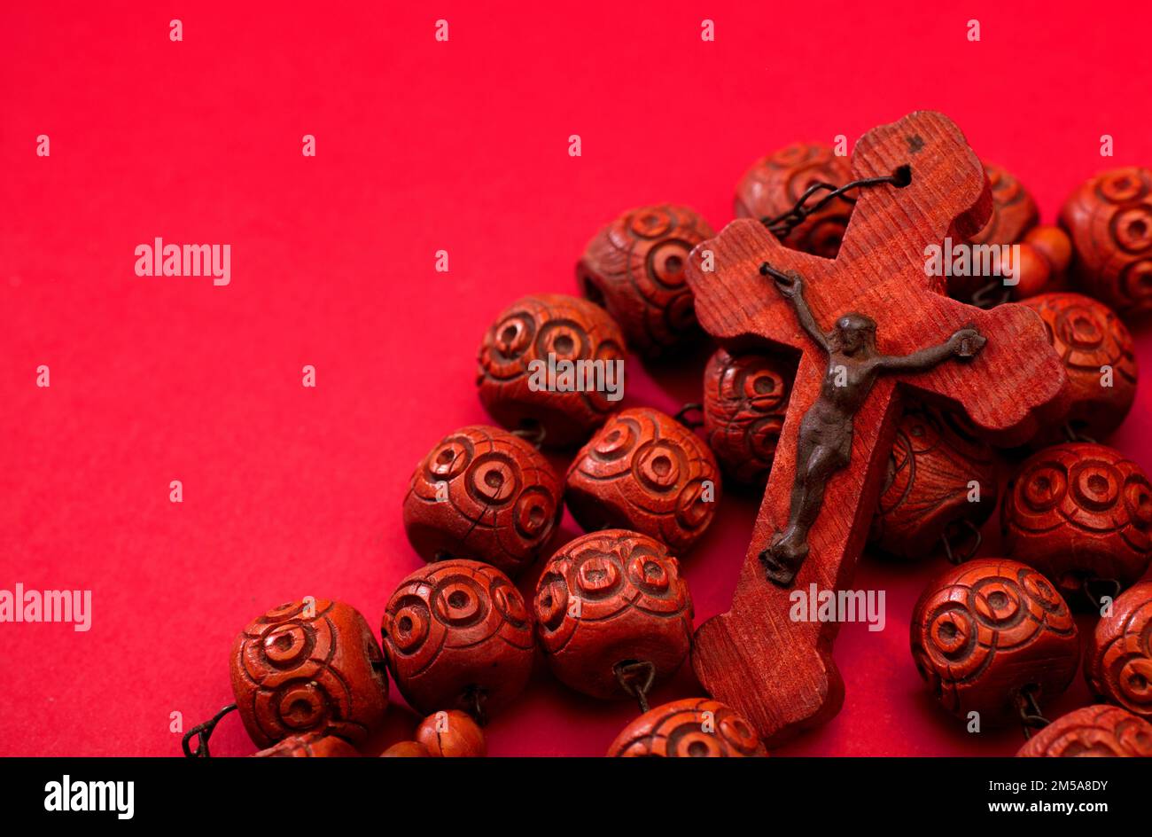 red wooden catholic rosary on a red background, space for text Stock ...