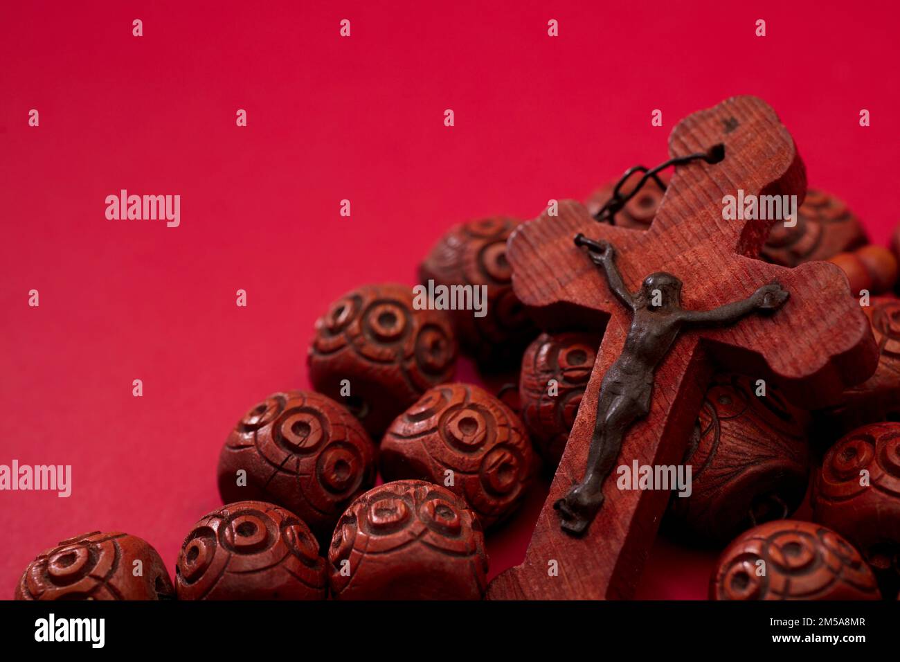 red wooden catholic rosary on a red background, space for text Stock ...