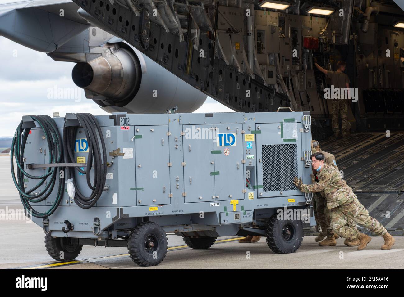 Airmen assigned to the 726th Air Mobility Squadron unload a generator ...