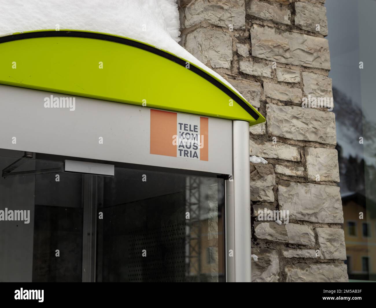 Telekom Austria logo on a telephone booth in the city. Snow is lying on ...