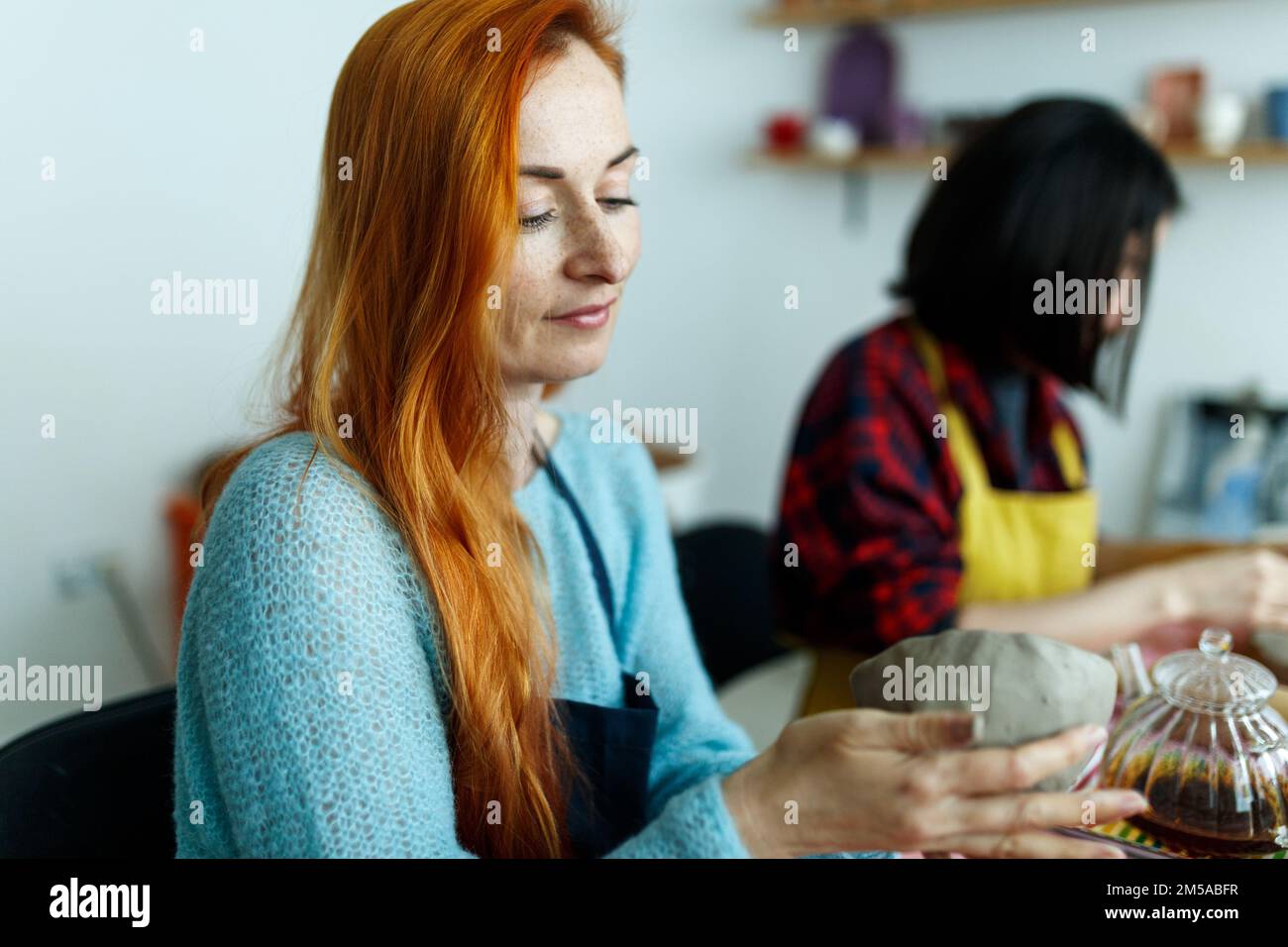 Female pottery artist preparing clay for molding. Close Up view of ... Female pottery artist preparing clay for molding. Close Up view of ...