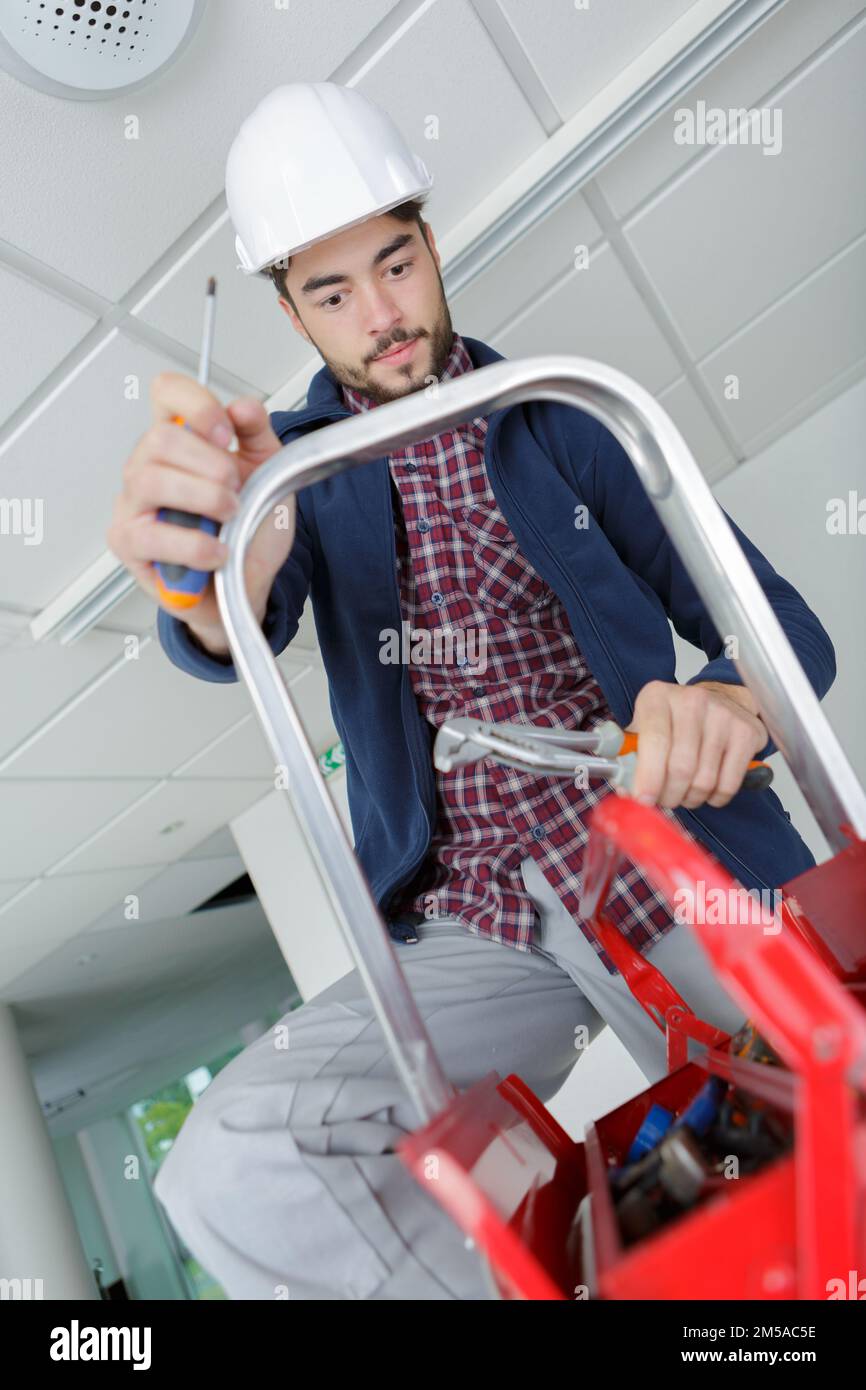 technician on the ladder with toolbox Stock Photo - Alamy