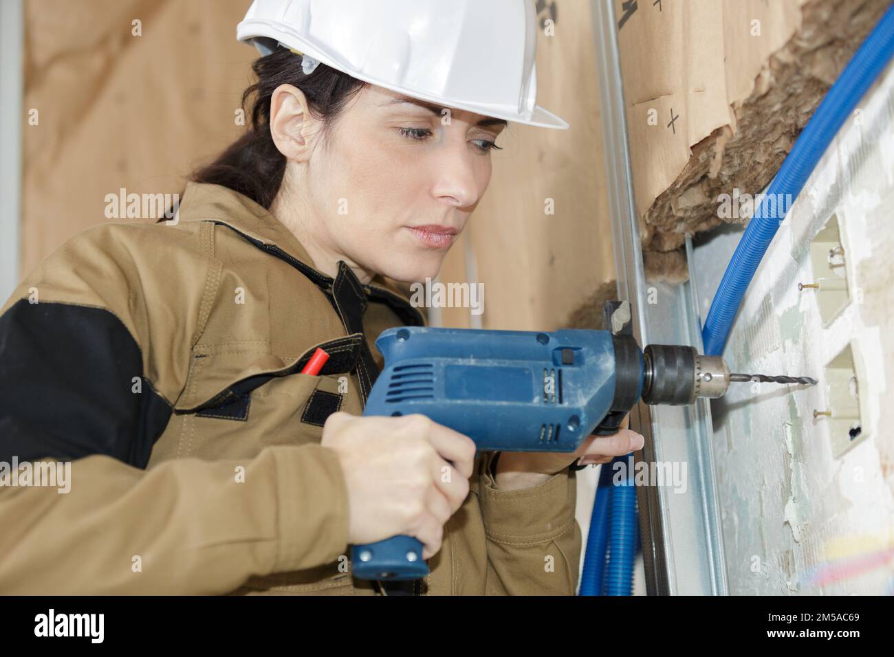 female construction worker drilling Stock Photo - Alamy