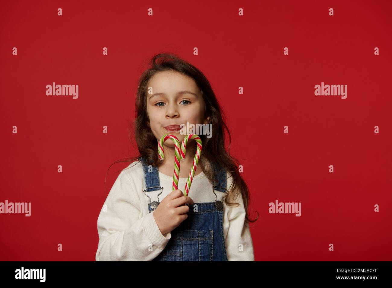 Beautiful little girl child holding sweet red green candy canes and ...