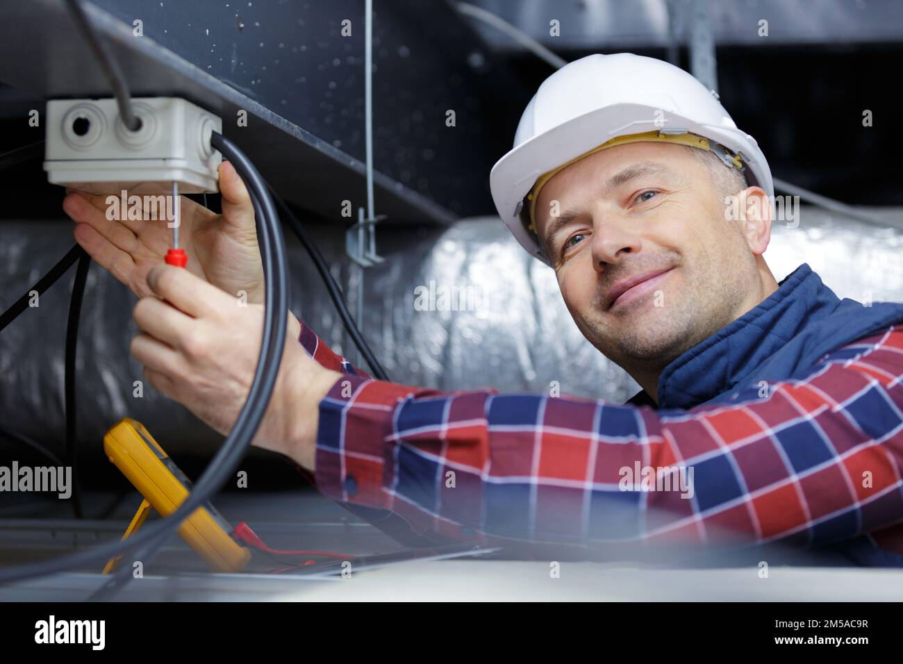 electrician fitting a cable for ceiling light Stock Photo - Alamy