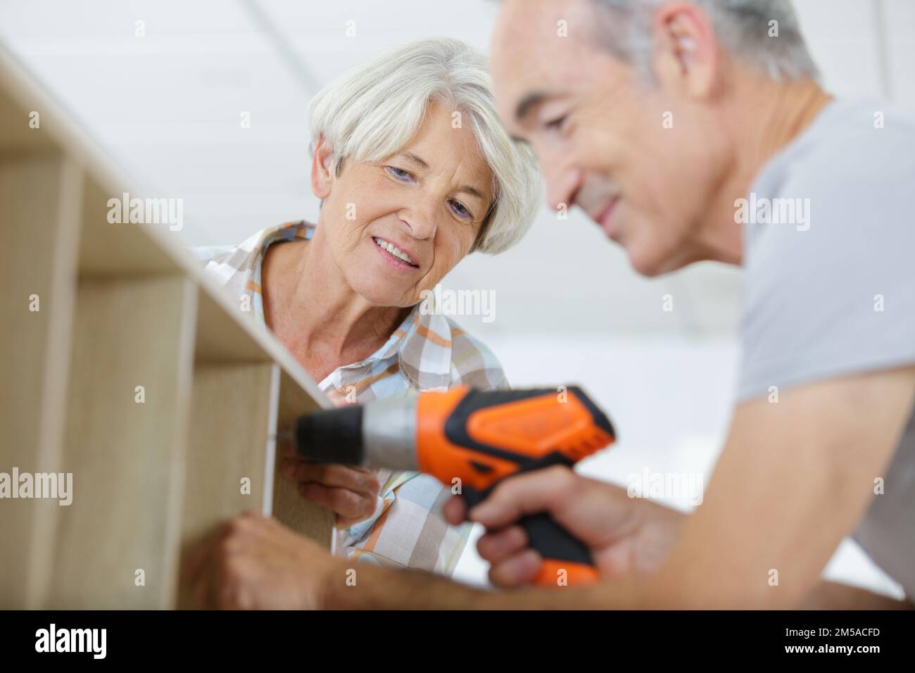happy older couple holding diy tools Stock Photo - Alamy