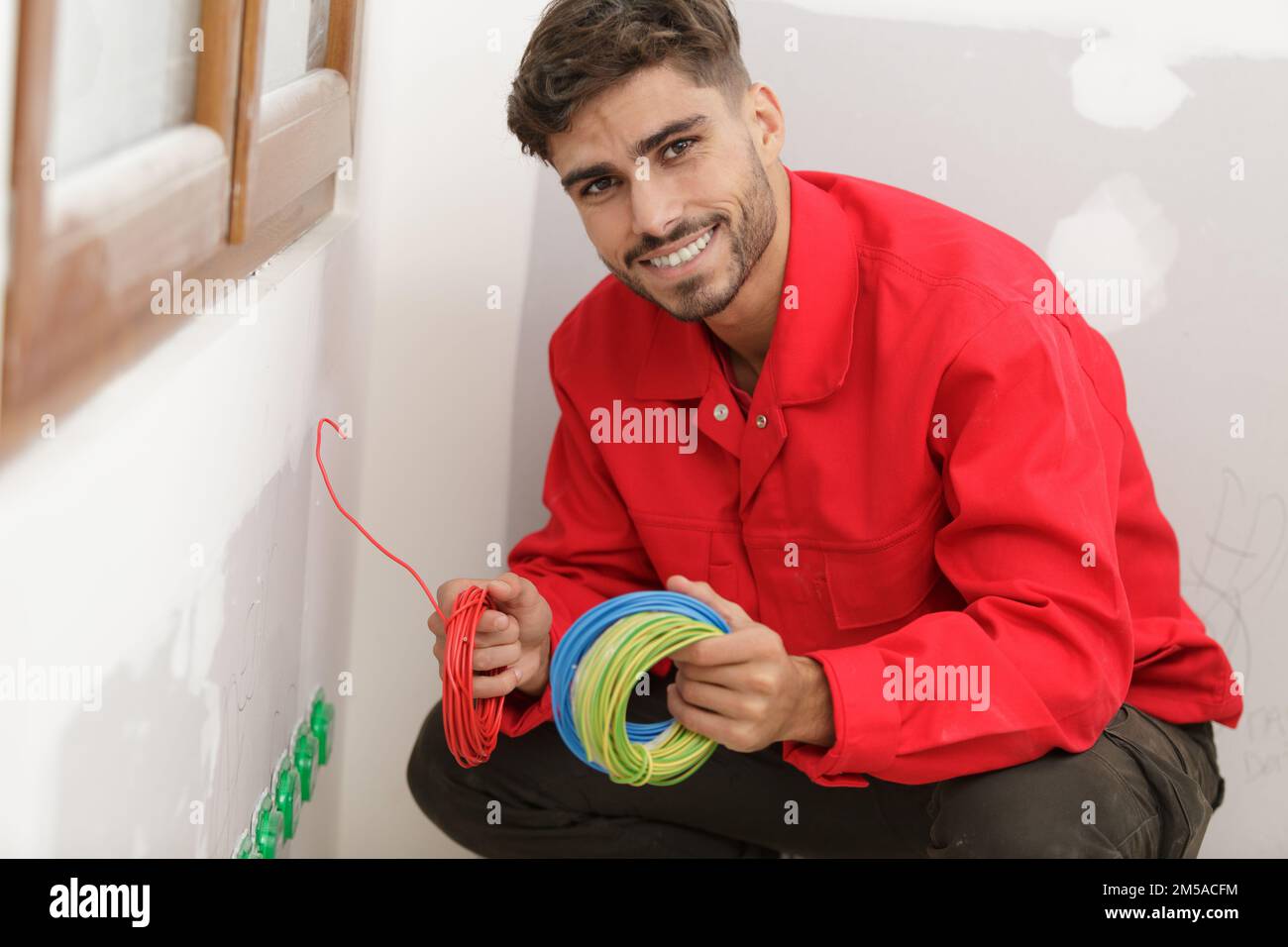 young smiling electrician with bunch of wires Stock Photo - Alamy