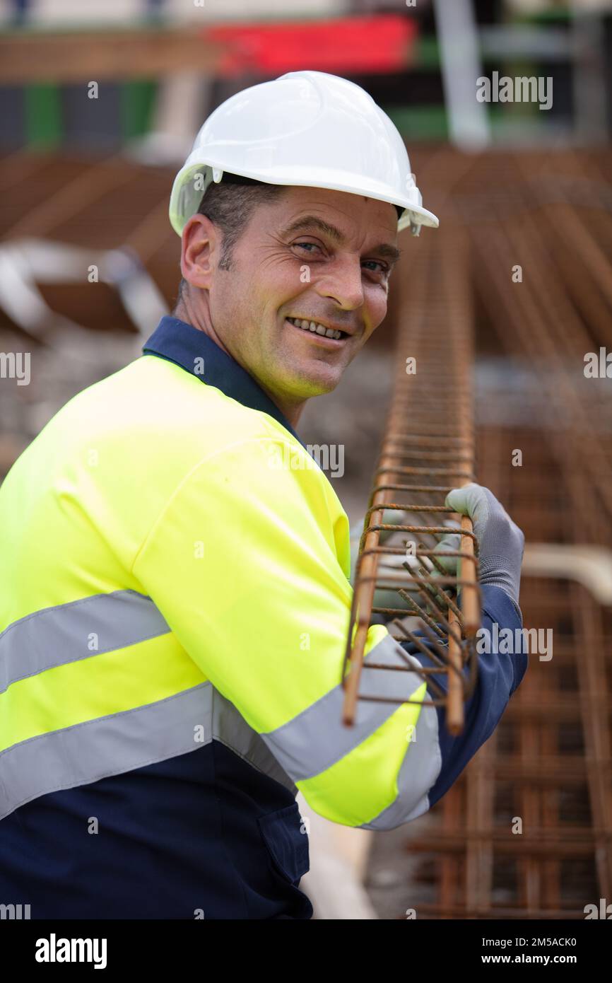 handsome worker carrying metal rod Stock Photo - Alamy