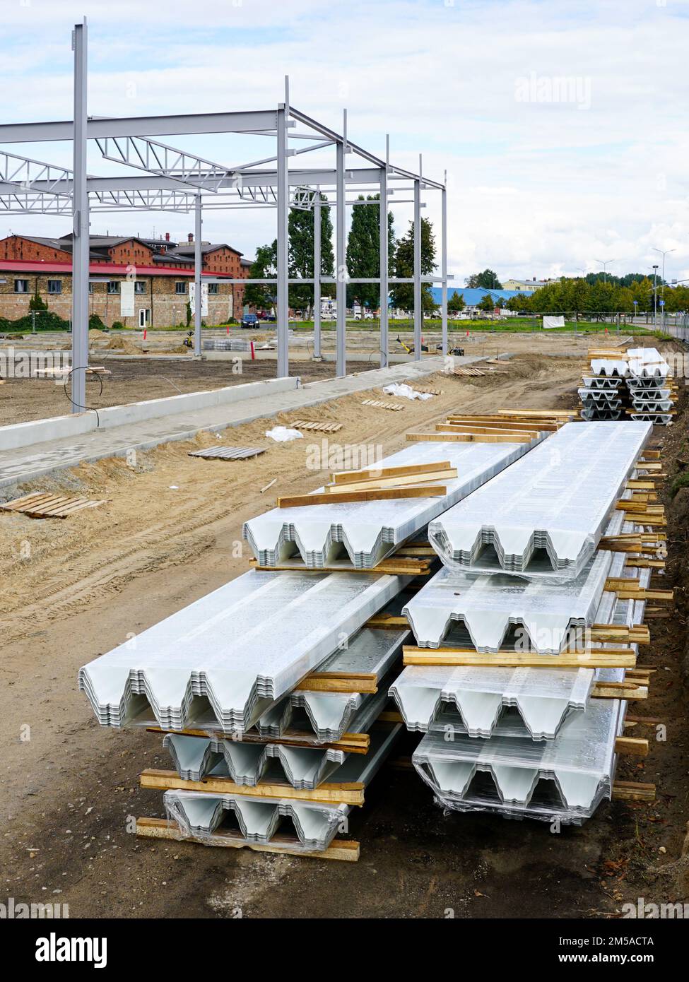 Stack of new corrugated steel roof panels on construction site and ...