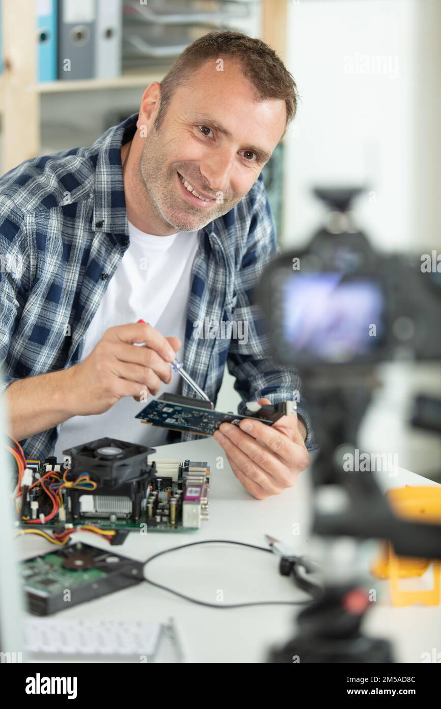 male blogger filming himself repairing a computer Stock Photo - Alamy