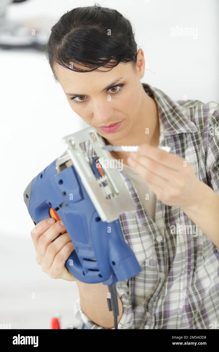 women is changing a blade of a cutting machine Stock Photo - Alamy