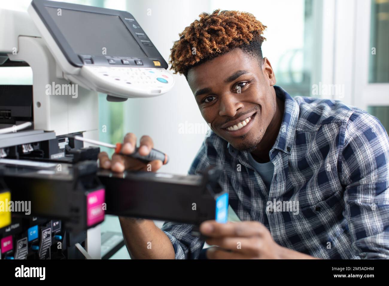 happy young technician repairing a printer Stock Photo - Alamy