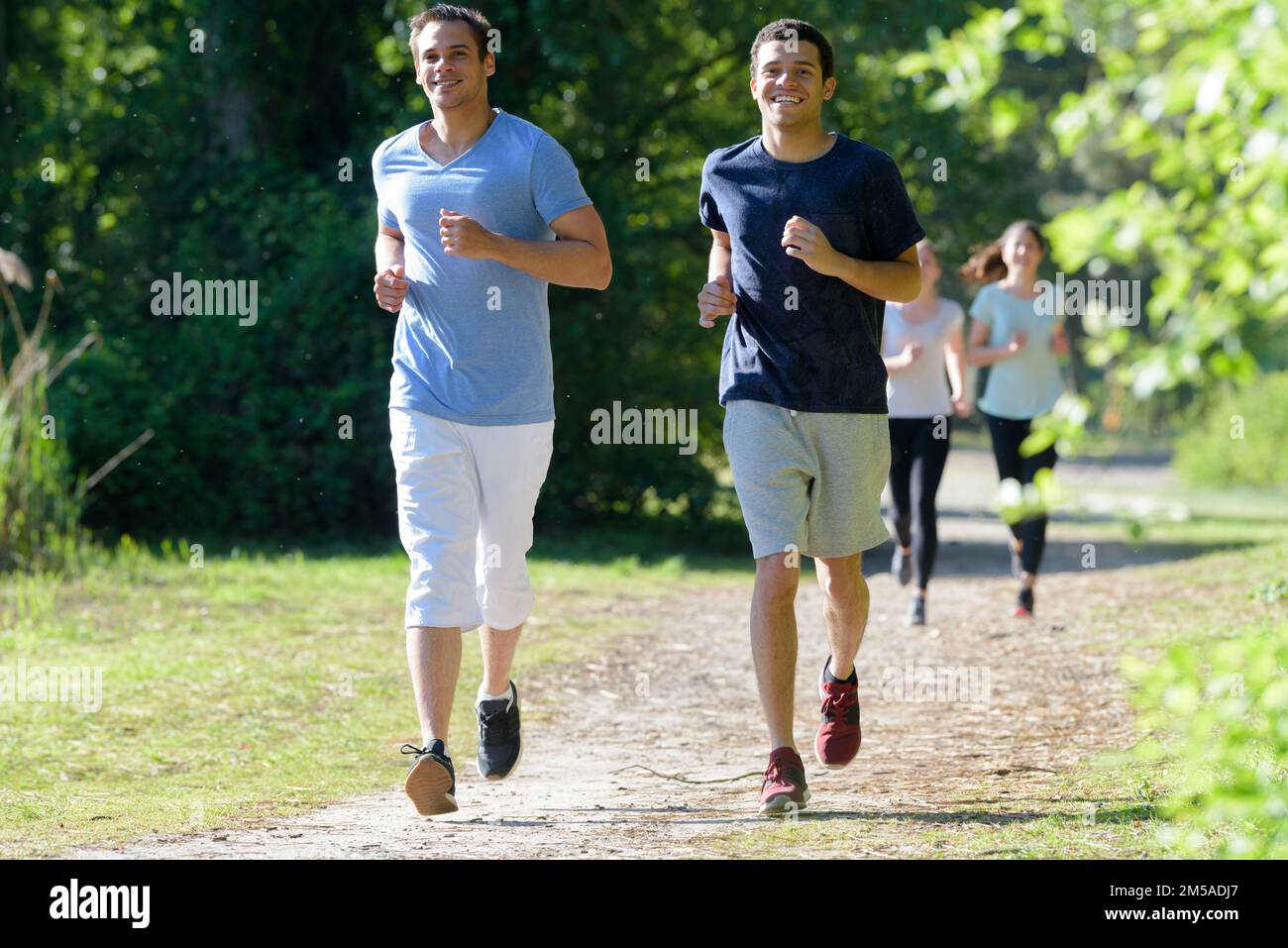 four people jogging two men in front two women behind Stock Photo - Alamy