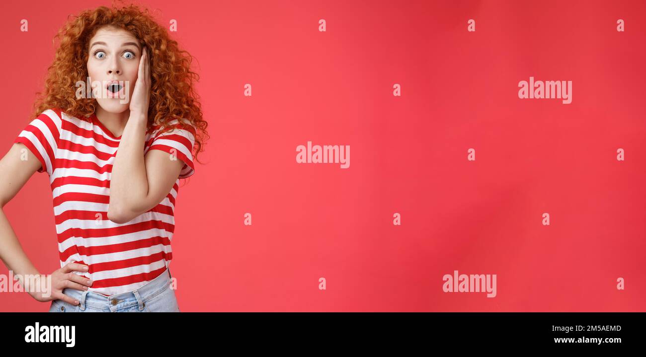 Shocked amused emotive redhead ginger girl curly haircut popping eyes ...