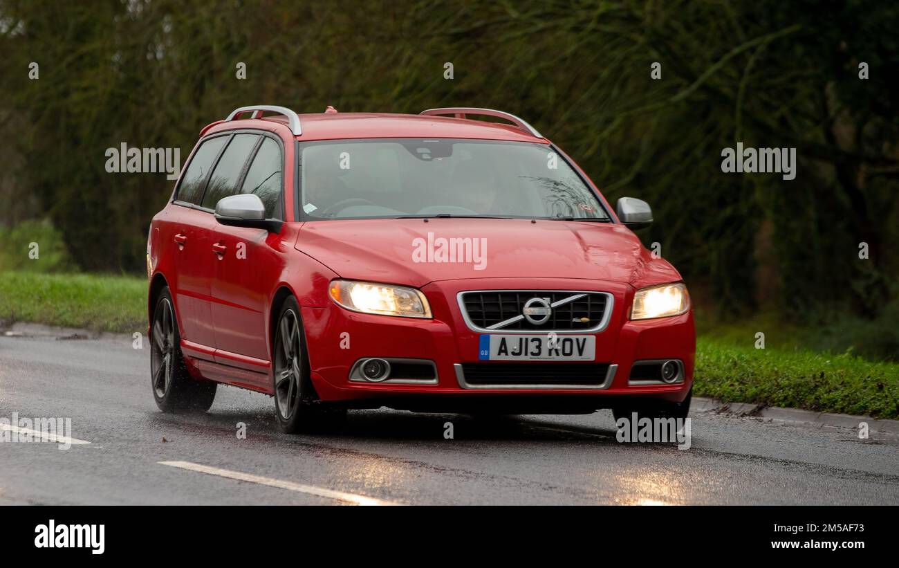 2013 red Volvo V70 estate car driving in the rain with headlights on ...