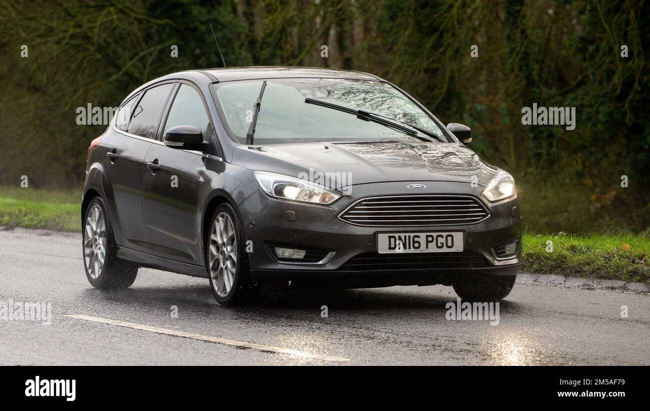 2016 grey diesel engine Ford Focus driving in the rain with headlights ...
