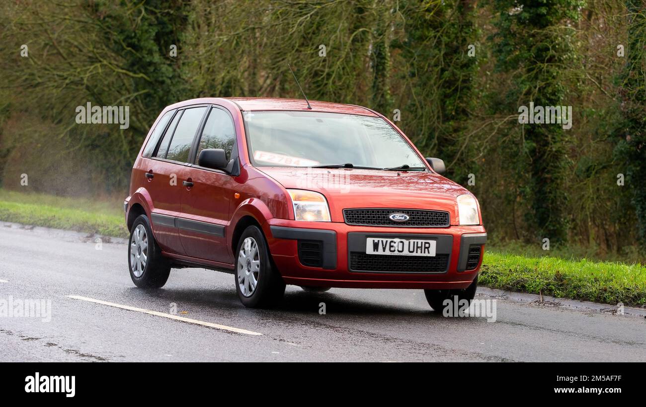 2010 red diesel engine Ford Fusion car driving on a wet road Stock ...