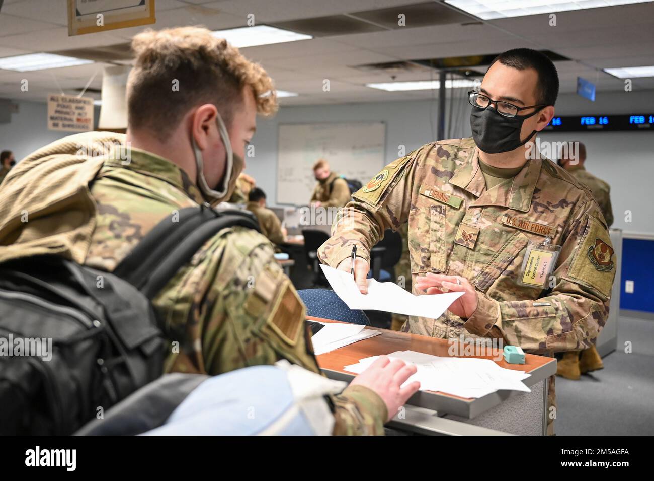 Tech. Sgt. Marc Dennis (right), 75th Medical Group, processes an Airman ...