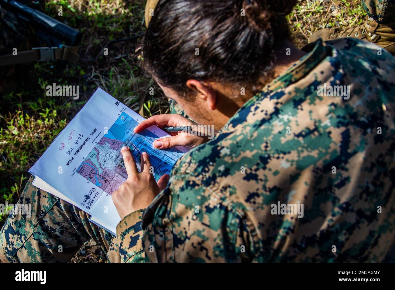 A U.S. Marine with 3d Marines, 3d Marine Division plots points on a map ...