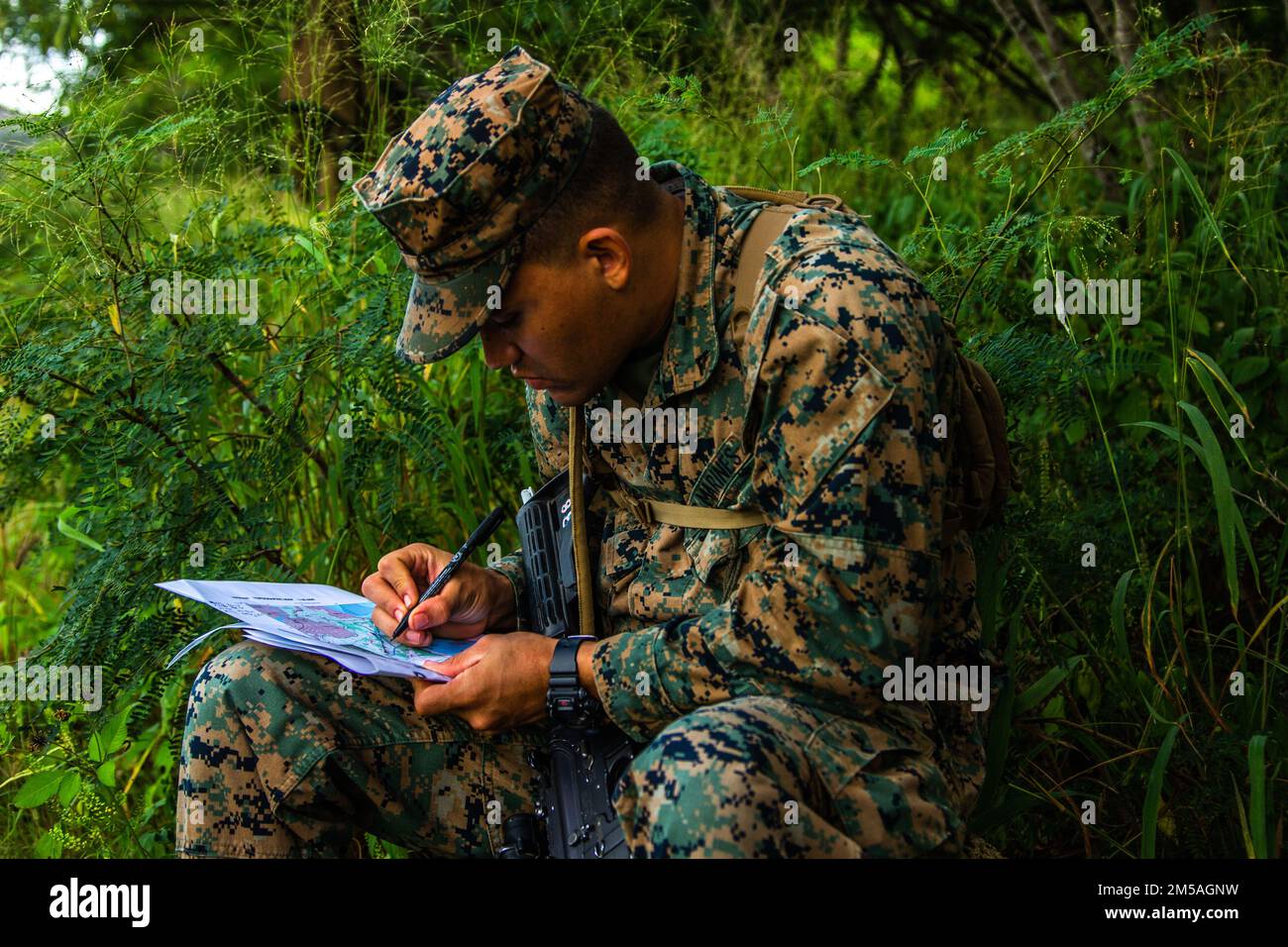 A U.S. Marine with 3d Marines, 3d Marine Division plots points on a map ...