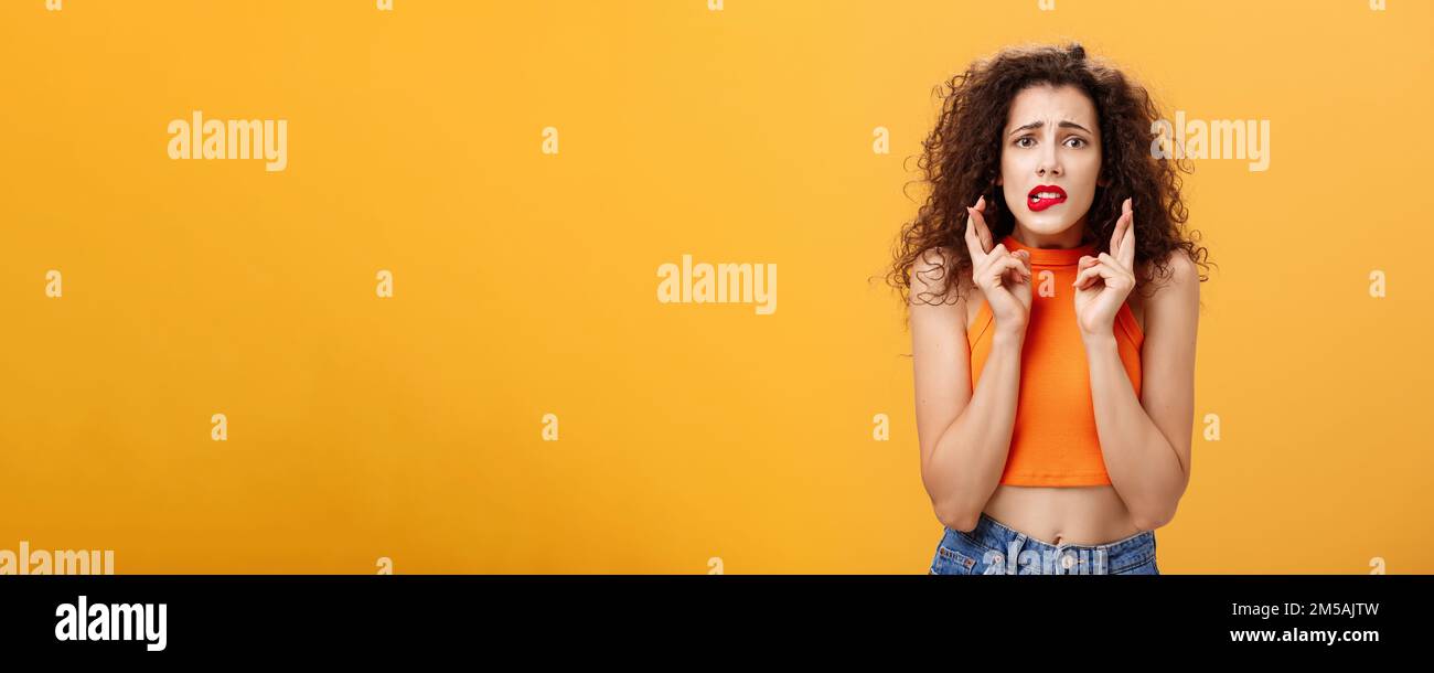 Worried and anxious silly caucasian female with curly hair in red ...