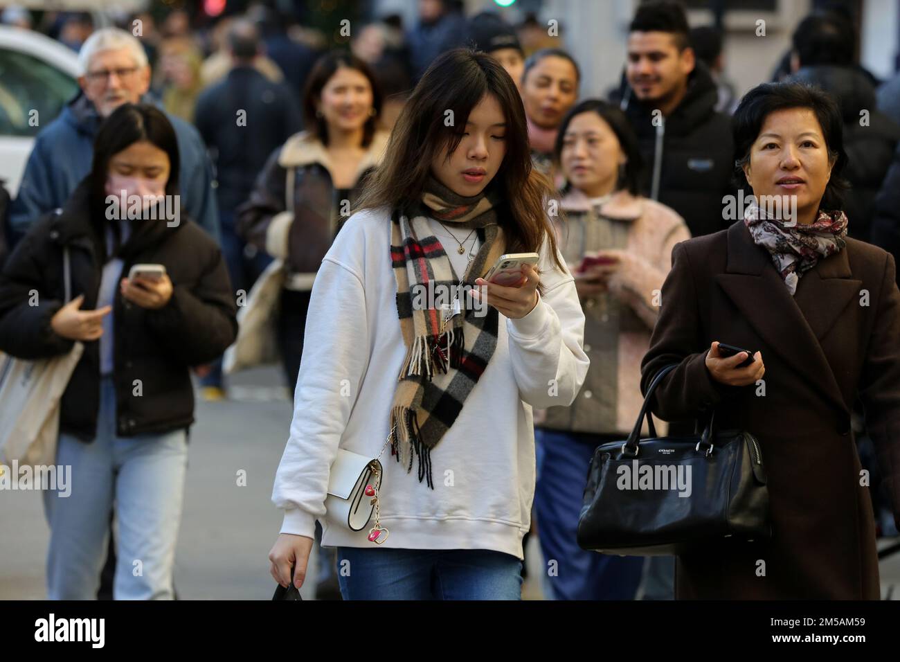 London, UK. 26th Dec, 2022. Women using their mobile phones while ...