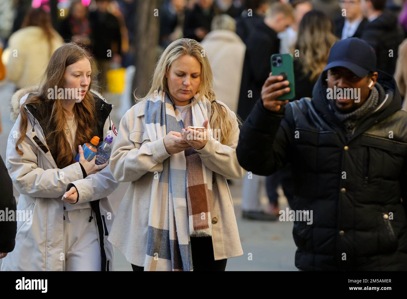 London, UK. 26th Dec, 2022. People using their mobile phones while ...