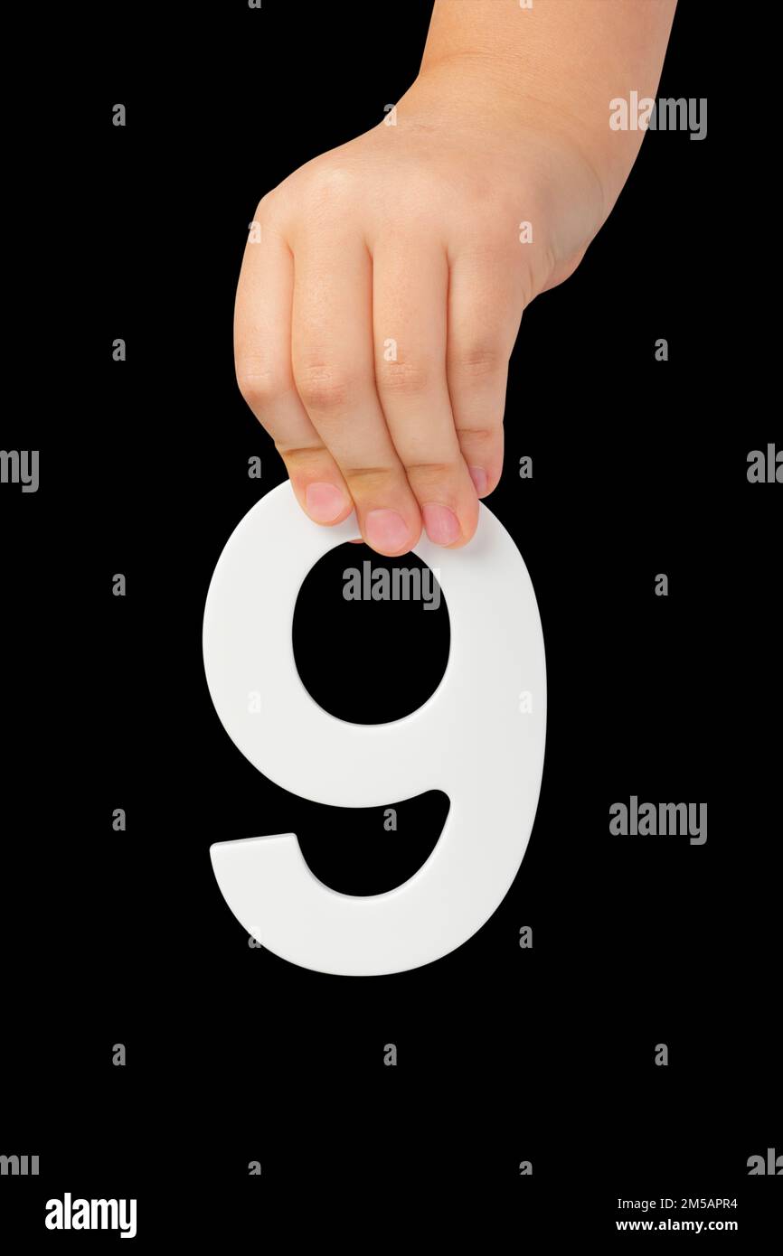 Number nine in hand isolated on black background. Number 9 in a child's ...