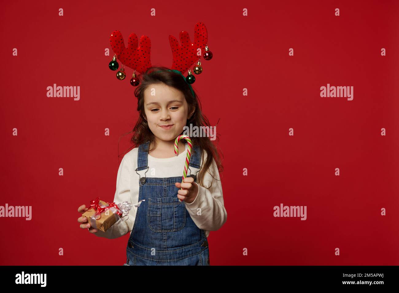 Cheerful adorable little girl wearing deer antler hoop posing with ...