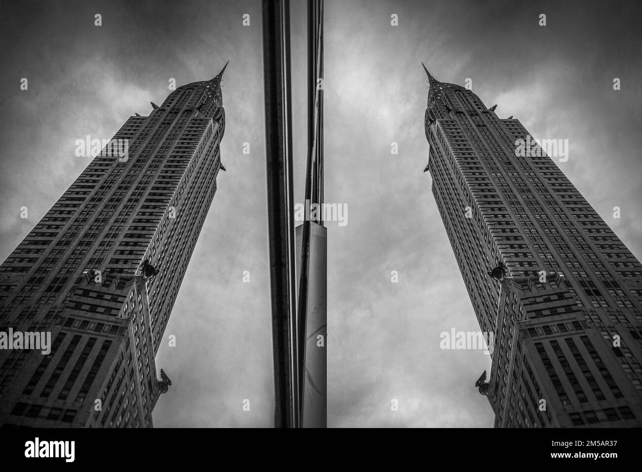 A black and white low-angle shot of the Chrysler Building with a reflection effect in New York ...