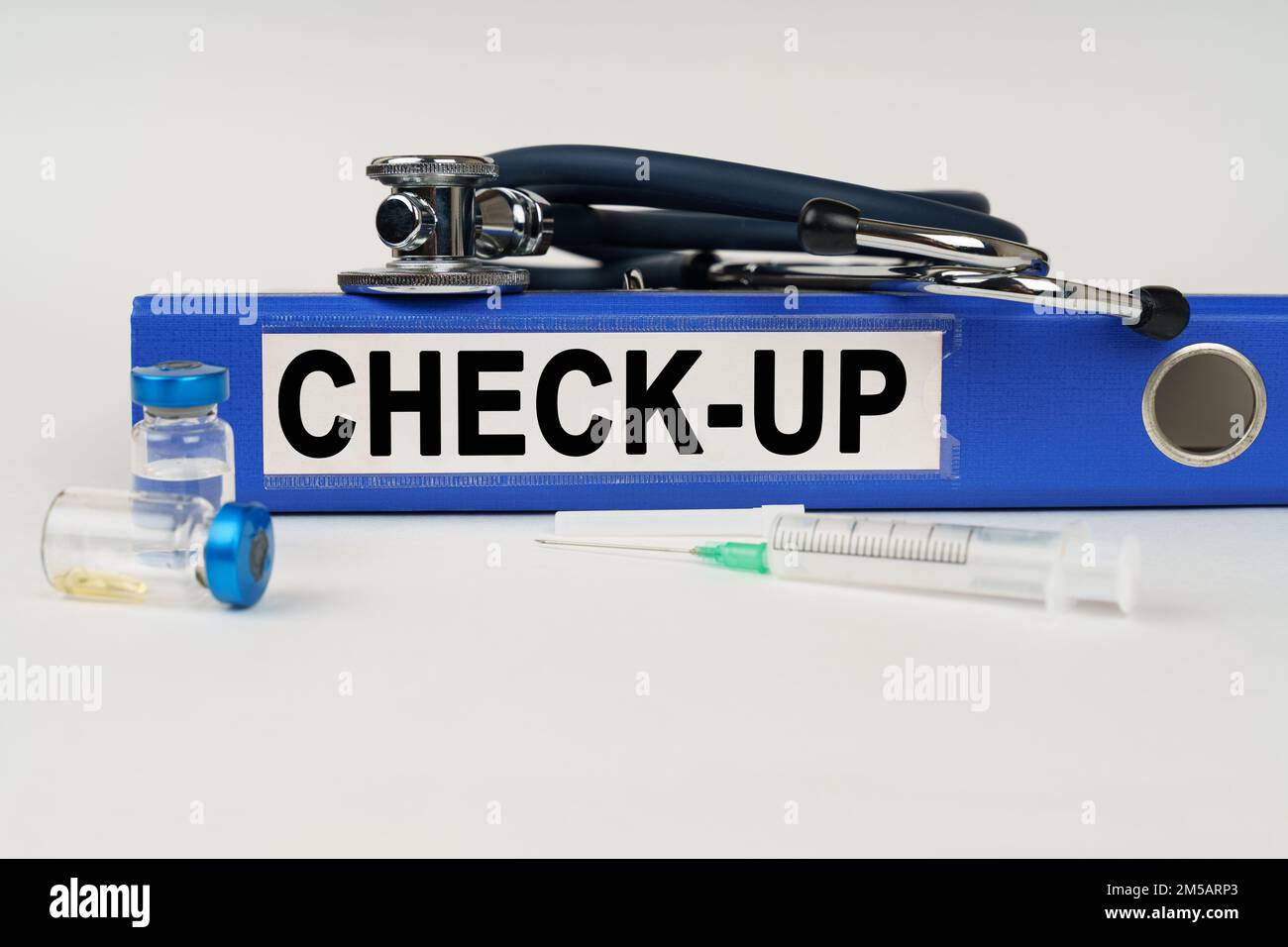 Medical concept. On a white surface, a syringe, a stethoscope and a ...