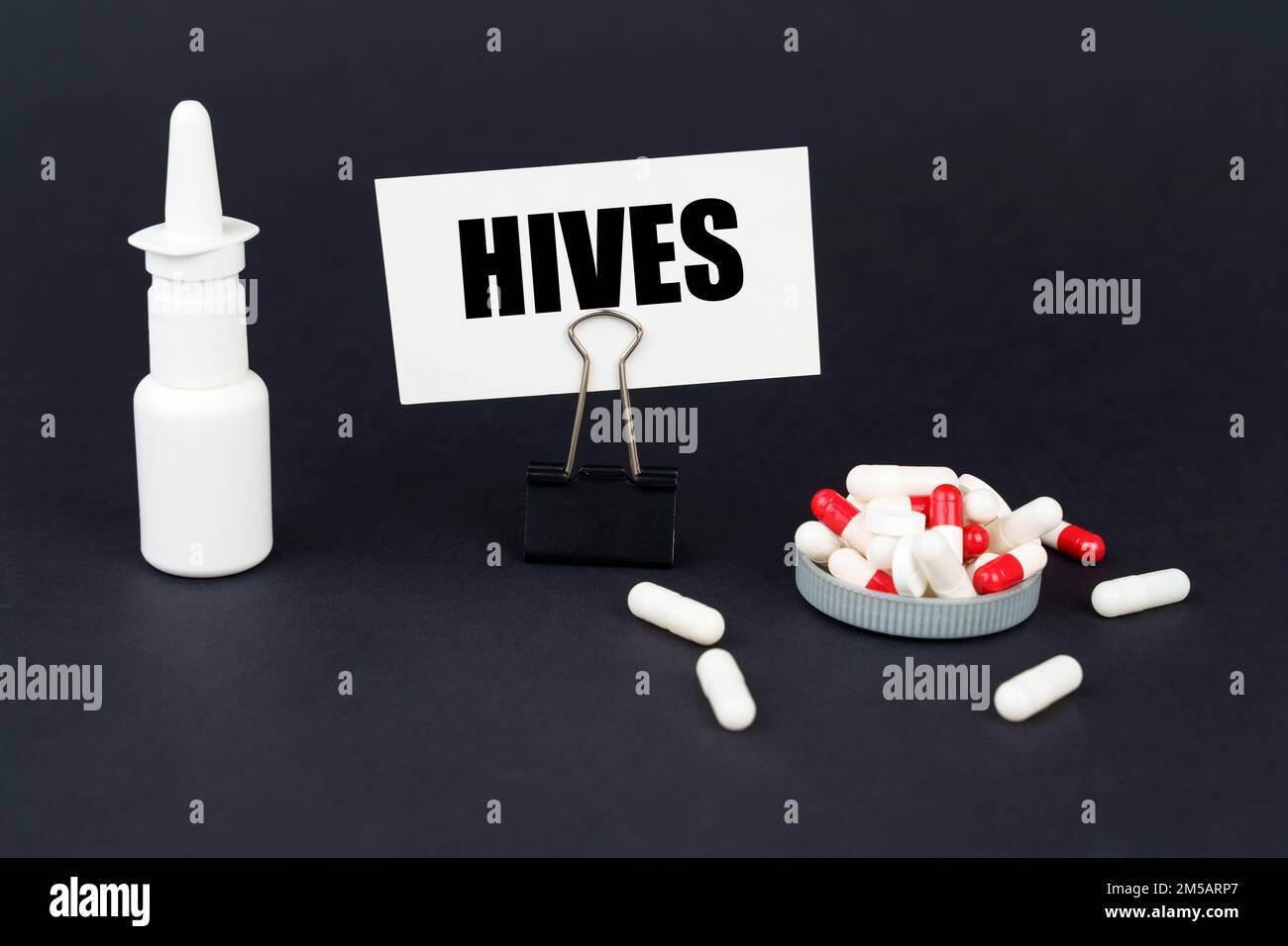 Medical concept. On the black surface of a pill, a nasal spray and a ...