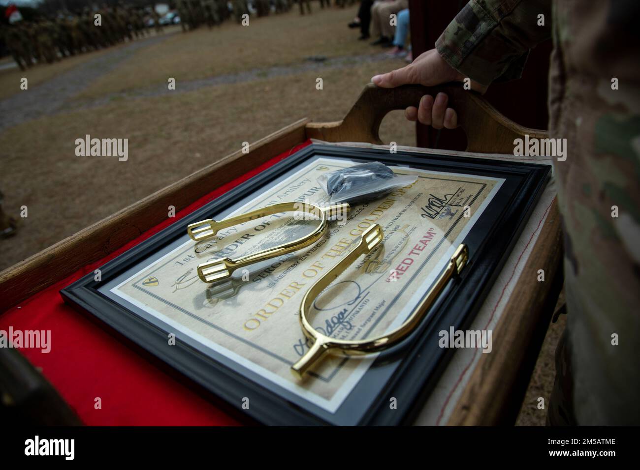 A Soldier holds a tray containing a pair of gold spurs and the “Order ...