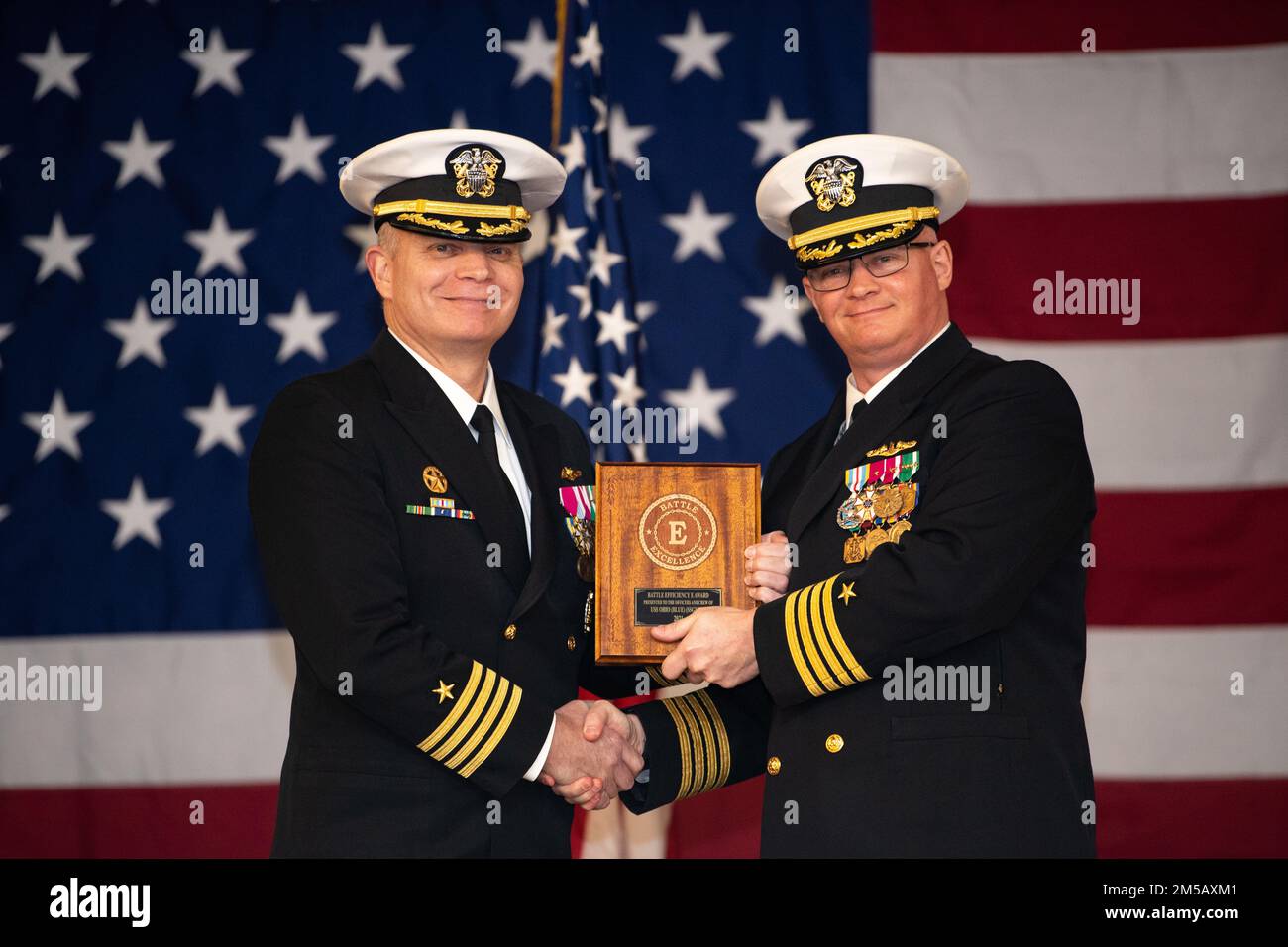 Capt. Brian Freck, left, receives the Battle ‘E” award from Capt. Shawn ...