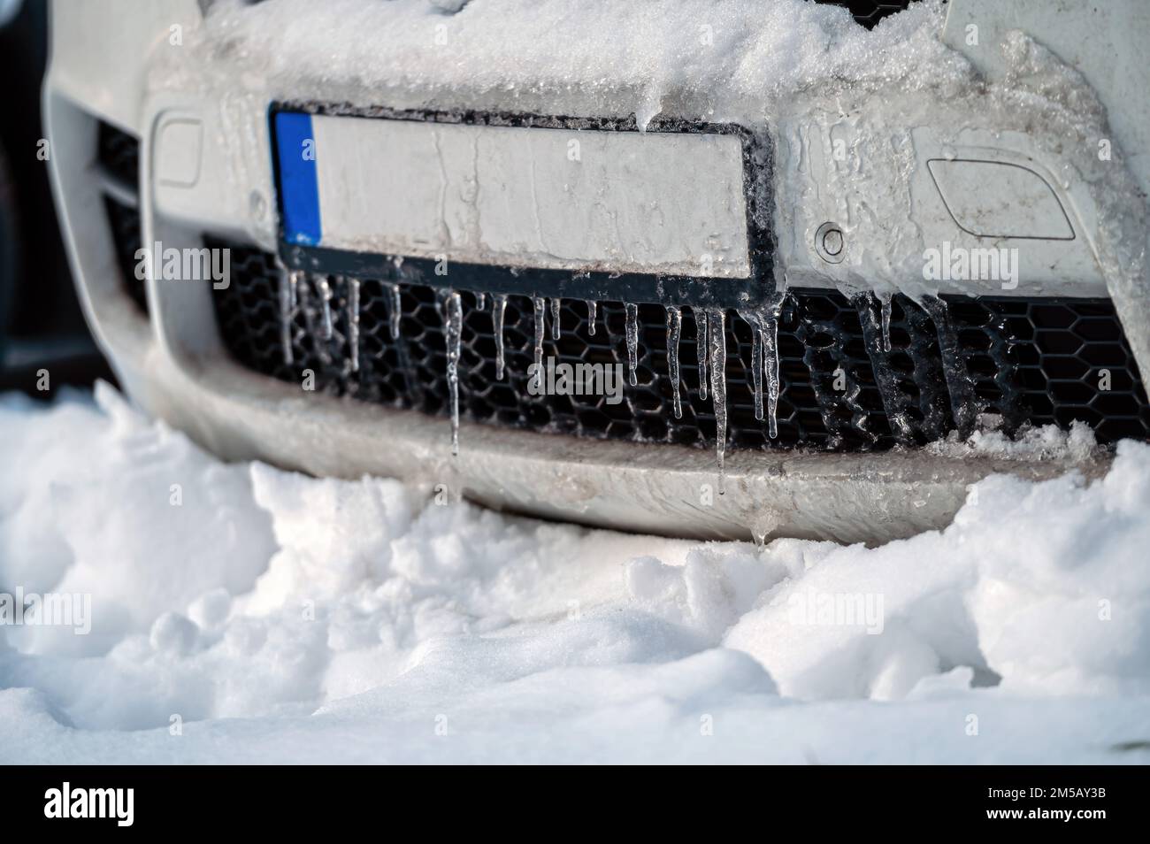 Car front bumper in icicles in winter. Frozen number plate car bumper ...