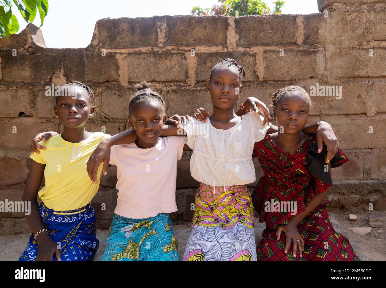 Front view of four pretty African classmates symbolising friendship and ...