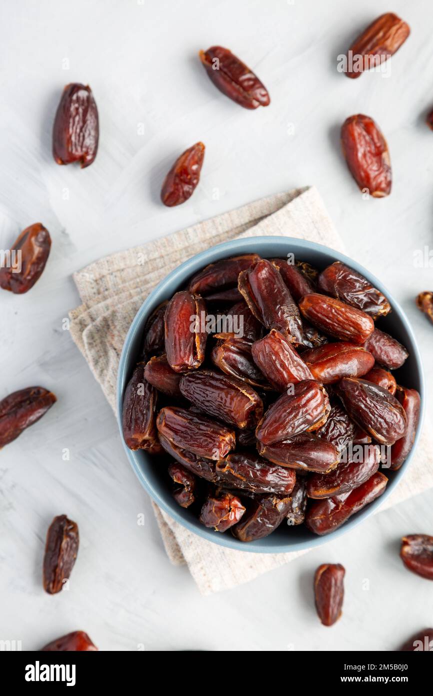 Pitted Organic Dates in Bowl on gray background, top view. Flat lay ...
