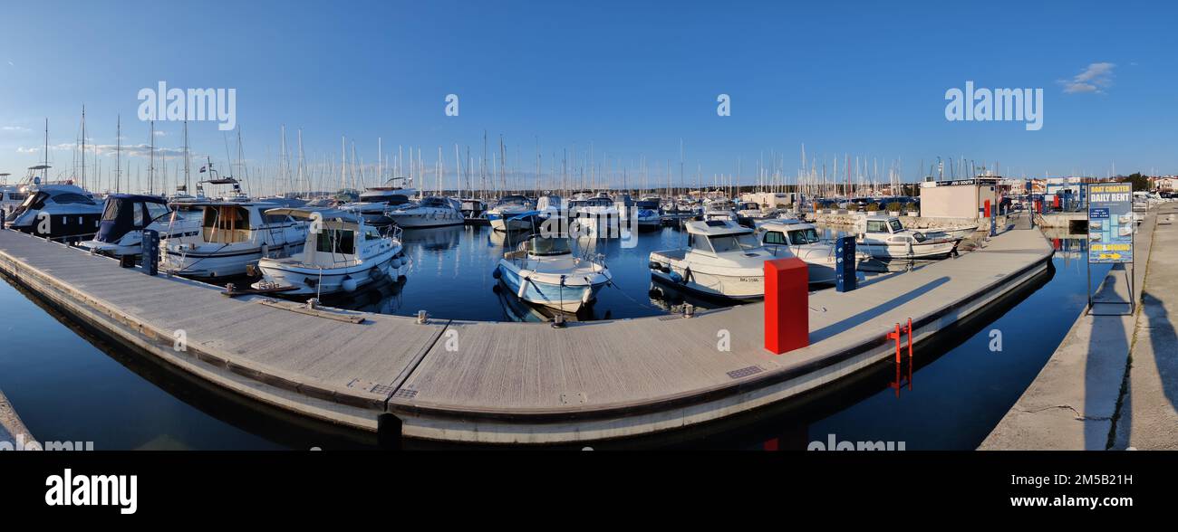 A panoramic view of an old narrow wooden harbor with boats on each side ...