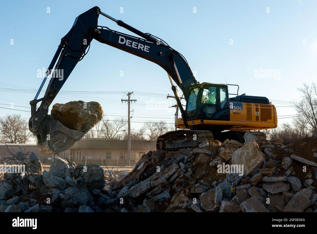An excavator removes larger pieces of rubble after demolition begins on ...